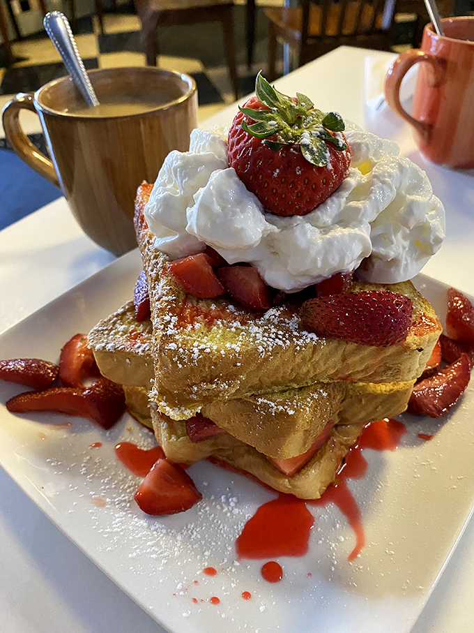 Not just French toast—it's a towering monument to morning indulgence. Strawberries, whipped cream, and powdered sugar create breakfast's answer to the Sistine Chapel.