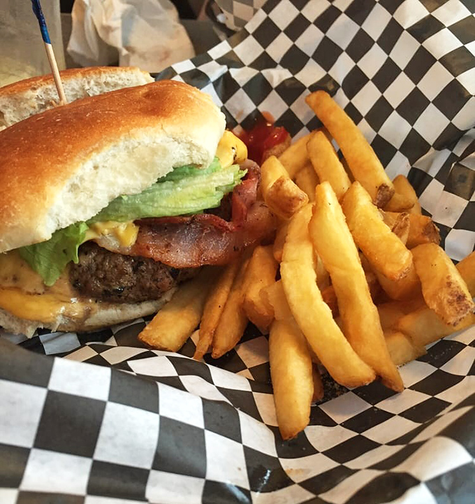 The burger that launched a thousand road trips—juicy, perfectly charred, and nestled on a checkered paper that's practically American formal wear.