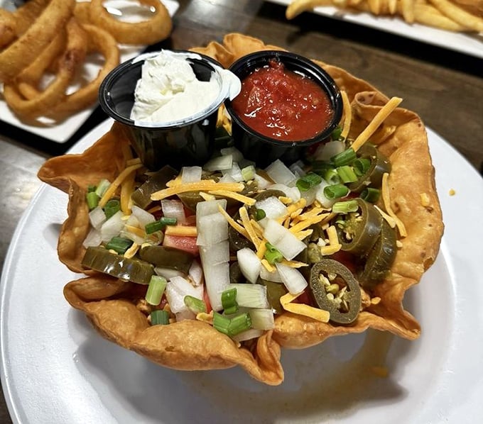 The famous taco salad arrives like edible architecture – a crispy tortilla bowl cradling fresh ingredients with salsa and sour cream standing by as faithful sidekicks.
