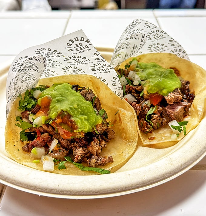 These tacos don't need Instagram filters—perfectly grilled meat, fresh cilantro, onions, and guacamole create edible poetry on handmade tortillas.