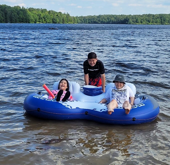 Family memories being made in real-time on Promised Land Lake. That inflatable raft—the unofficial throne of summer vacation royalty.