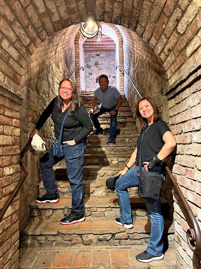 Down the rabbit hole and into history! Visitors explore the castle's narrow stone passageways, where every brick tells a story.