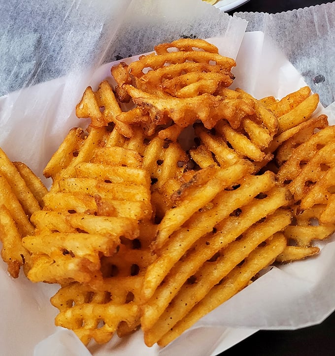 Behold the waffle fries—architectural marvels of potato engineering with their perfect grid pattern designed to maximize both crispiness and ketchup-holding capacity.