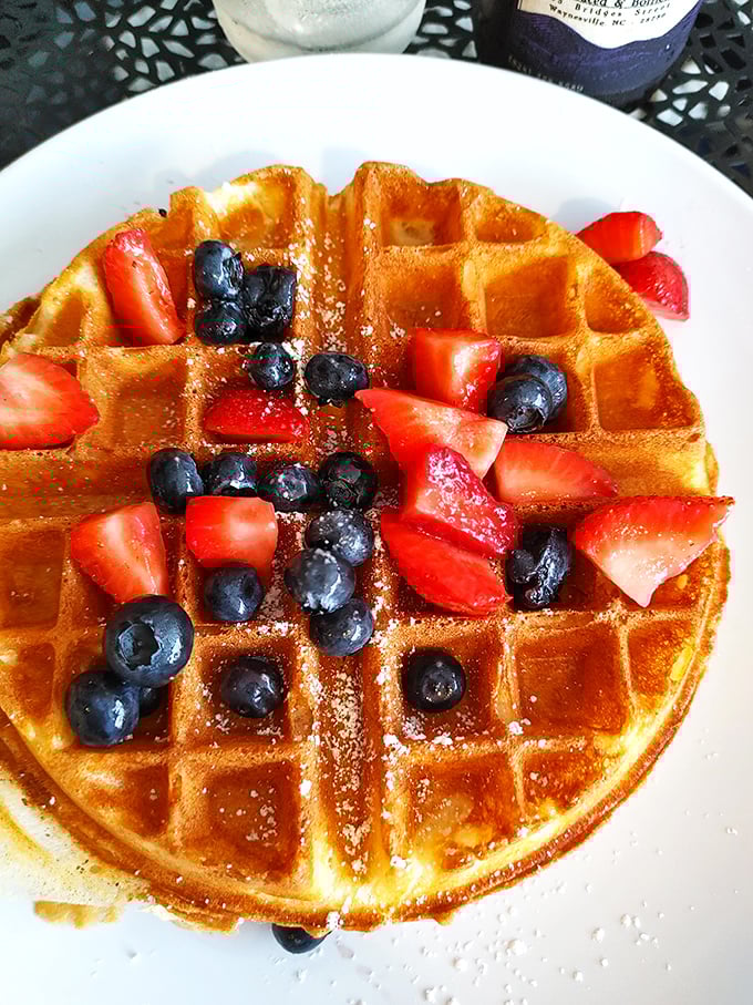 Golden waffle perfection crowned with fresh berries – nature's candy making a perfectly acceptable breakfast that somehow feels both virtuous and indulgent.