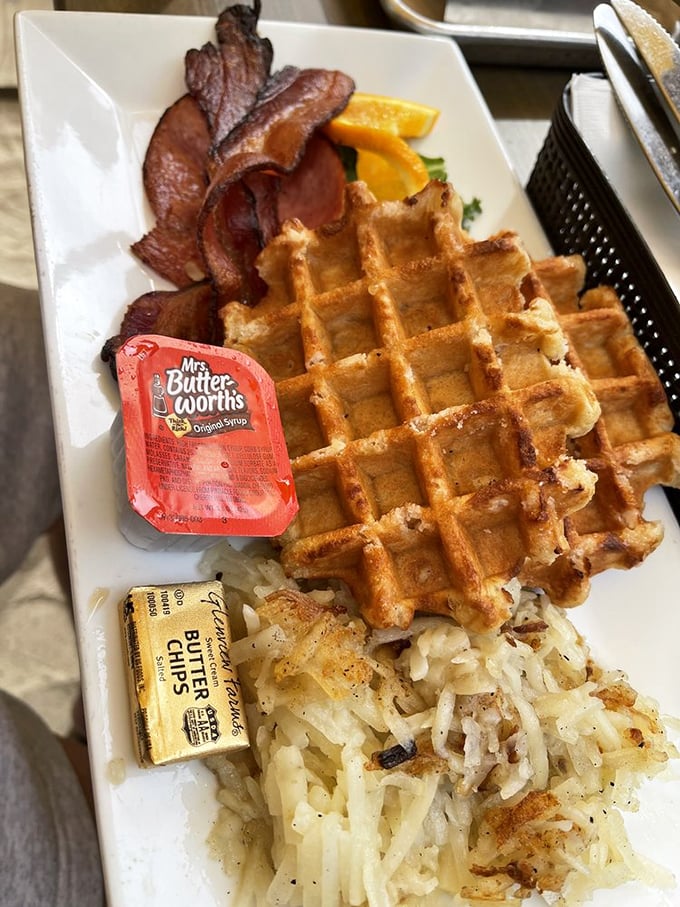 The legendary waffles arrive golden and crispy outside, cloud-soft inside—paired with perfectly crisped bacon and hash browns that would make your grandmother jealous.