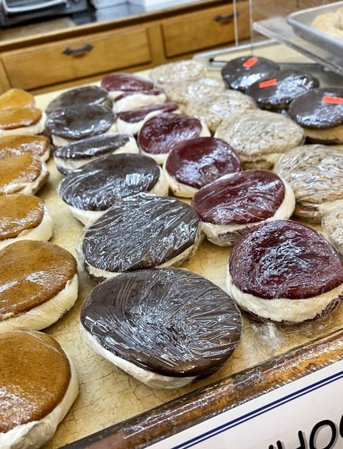 Whoopie pies lined up like edible hockey pucks – chocolate, vanilla, and berry versions waiting to jump into your take-home box.