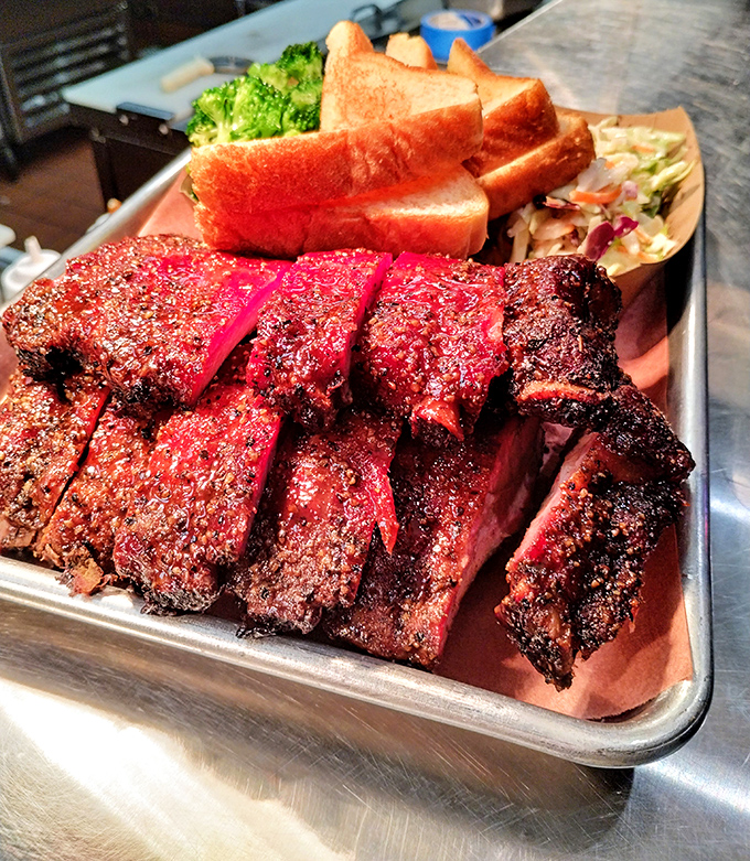 Behold the beef ribs—prehistoric-looking masterpieces with a smoke ring so perfect it could make a pitmaster weep with joy.