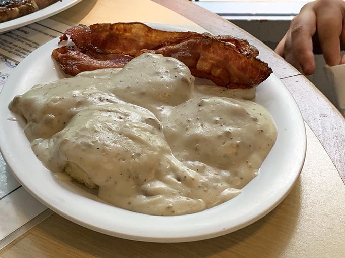Behold the star attraction: biscuits drowning in a sea of peppery sausage gravy. This plate alone has probably convinced countless hikers to delay their Smoky Mountain adventures.