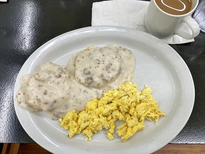 Behold the holy grail of Southern breakfast: pillowy biscuits smothered in peppery sausage gravy alongside fluffy scrambled eggs. Poetry on a plate, Florida-style.
