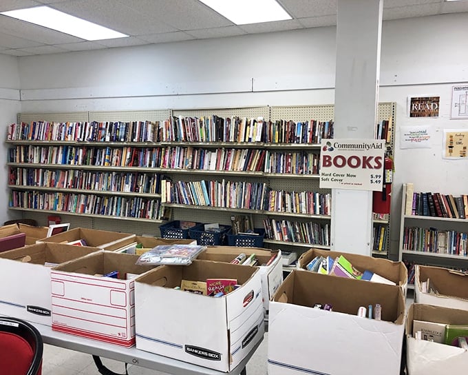 A community thrift store’s book section, featuring shelves and boxes filled with a wide variety of affordable books, inviting readers to explore and find their next great read.