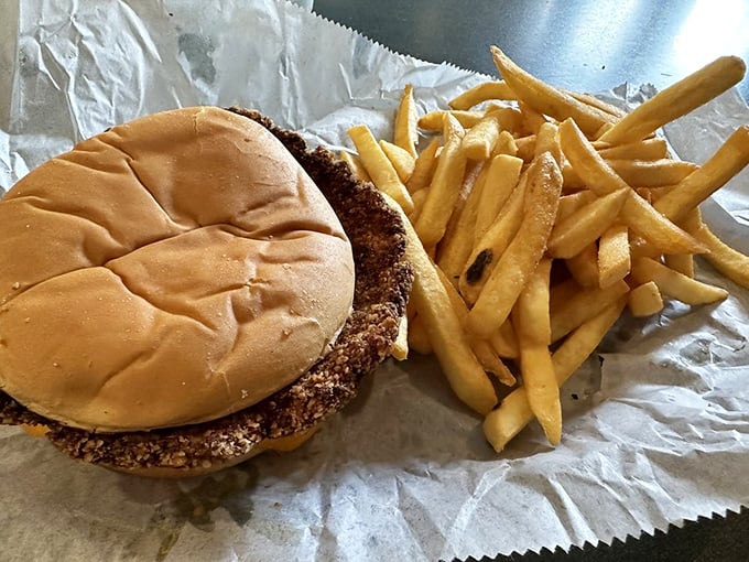 Indiana's state sandwich in its natural habitat – a breaded tenderloin so magnificently oversized it makes the bun look like it's playing a supporting role.