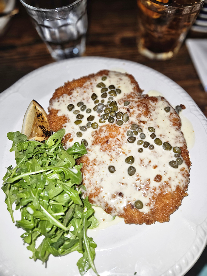 The star of the show: breaded pork loin that's crispy, tender, and topped with capers. This isn't just dinner—it's edible architecture with a side of arugula.