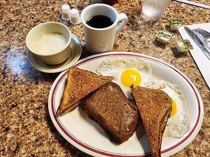 Two sunny-side-up eggs flanking perfectly toasted bread—breakfast simplicity that proves sometimes the classics deserve their legendary status for good reason.