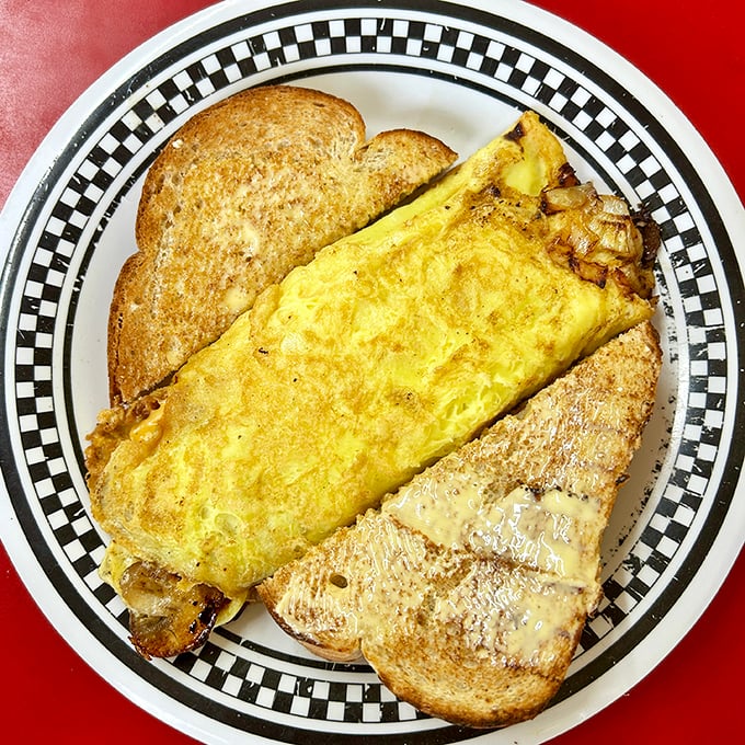 Behold the omelet that launched a thousand satisfied sighs—perfectly folded, generously filled, and flanked by toast that's achieved golden-brown perfection.