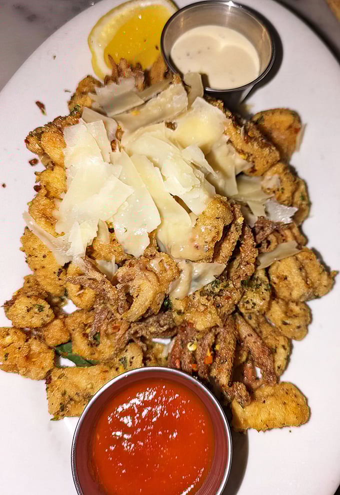 The legendary calamari that launched a thousand road trips—crispy, tender, and topped with shaved cheese that melts into seafood perfection.