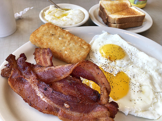 Breakfast perfection doesn't need a filter—crispy bacon, sunny-side eggs, and hash browns that would make your cardiologist wince but your soul sing.