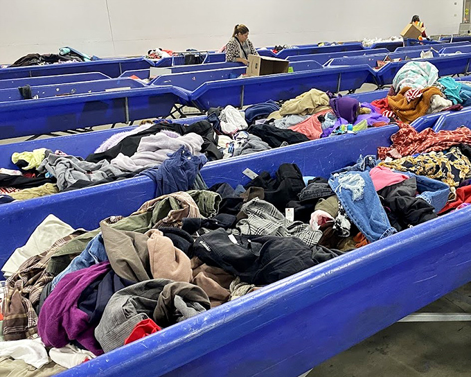Ocean-blue bins create waves of fabric possibilities—each layer potentially hiding that perfect cashmere sweater or vintage band tee.