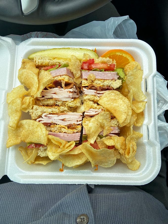 This club sandwich isn't playing around – stacked higher than my college debt and surrounded by a golden moat of potato chips.