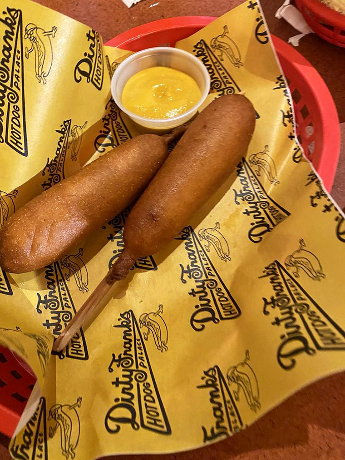 Two golden-brown corn dogs nestled on their signature yellow wrapper—proof that some childhood joys only get better with age.