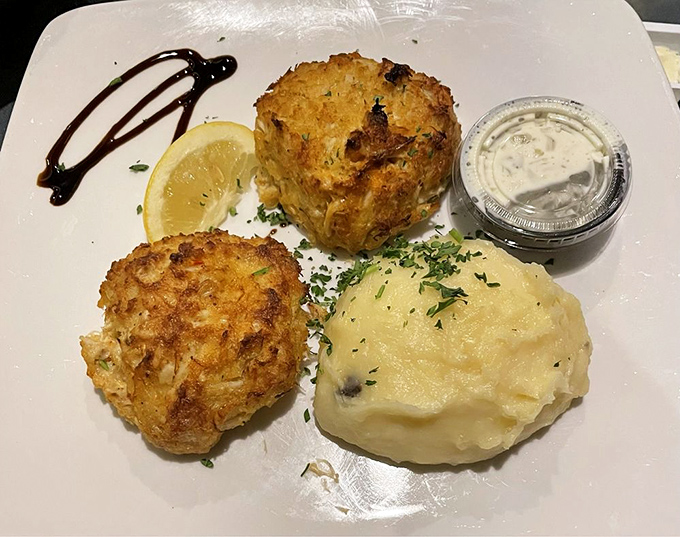 Golden-brown crab cakes that are more crab than cake—a refreshing concept in a world where "crab cake" often means "breadcrumb patty with crab rumors."