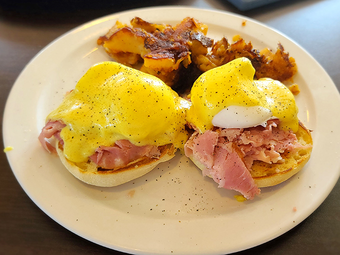 Eggs Benedict that would make a French chef weep with joy – perfectly poached eggs, savory ham, and hollandaise sauce that's basically liquid sunshine.