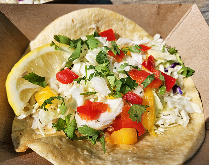 Fresh fish nestled in a warm tortilla, topped with a confetti of cabbage, cilantro, and peppers – this isn't just lunch, it's a California dream on a plate.