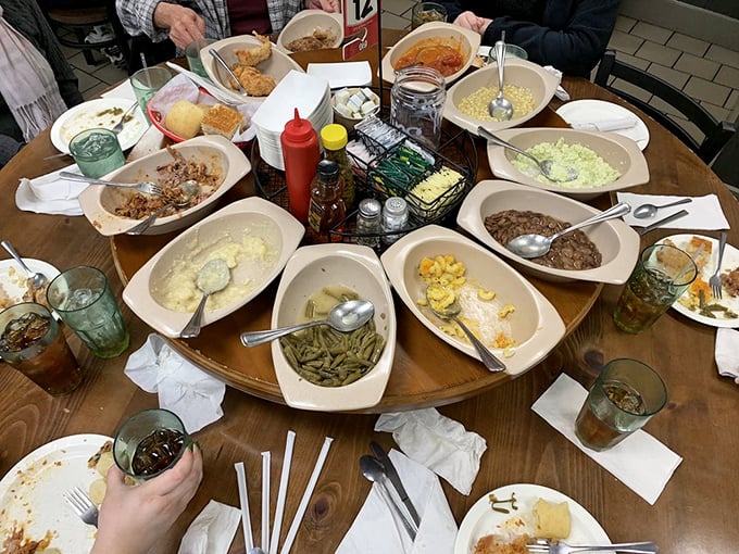 The lazy Susan in its natural habitat—a circular United Nations of Southern sides where diplomatic relations involve passing the mac and cheese without taking the last scoop.