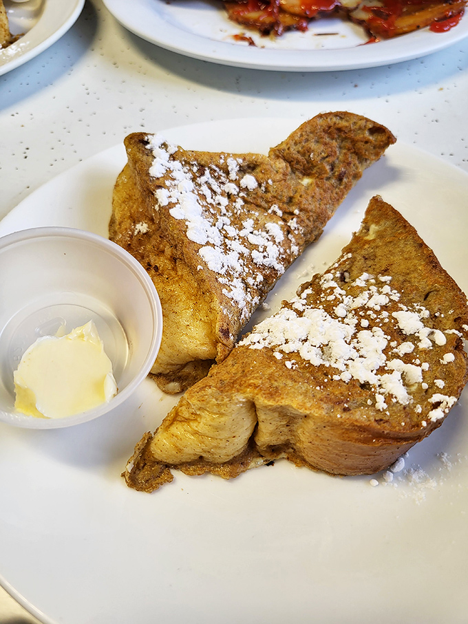 The legendary French toast in all its glory – golden-brown perfection dusted with powdered sugar, waiting for that first life-changing bite.