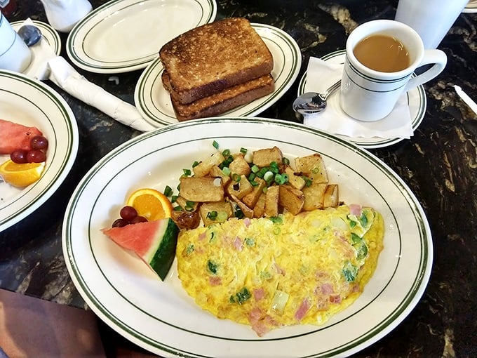 Behold the Western omelet in all its glory—fluffy eggs embracing ham and veggies with home fries standing guard. Breakfast perfection exists!
