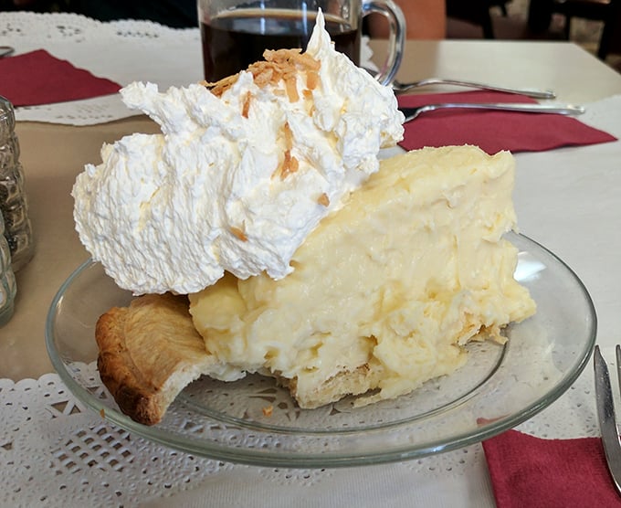 This coconut cream pie doesn't just satisfy a sweet tooth – it creates a lifelong commitment. That mountain of whipped cream deserves its own zip code.