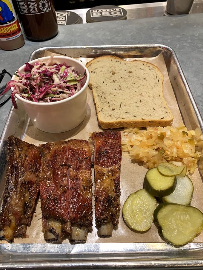 These ribs don't just fall off the bone—they practically leap into your mouth, accompanied by their faithful sidekicks: slaw, kraut, and pickles.