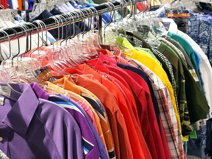 A rainbow of possibilities hangs in perfect order – each shirt representing both sustainable fashion and the chance to reinvent your style for pocket change.