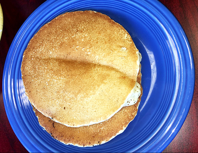 Golden pancakes that look like they were kissed by the sun gods. Perfectly round, perfectly browned, perfectly stacked – breakfast geometry at its most delicious.