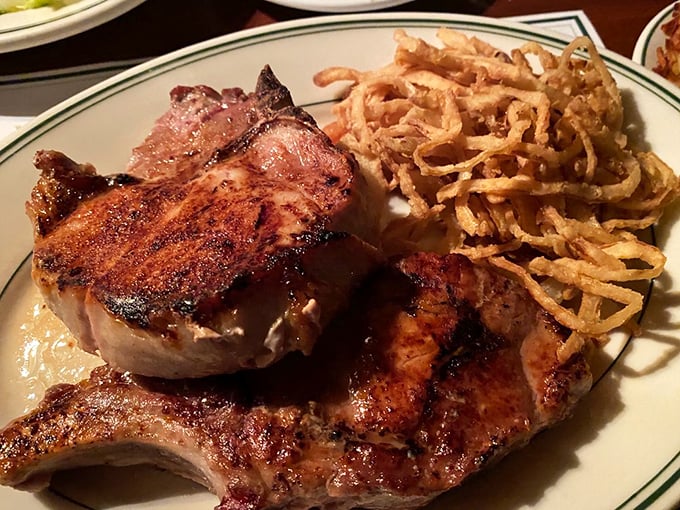 This pork chop isn't just dinner—it's architecture. The crispy onion strings provide the perfect textural counterpoint to that juicy meat.