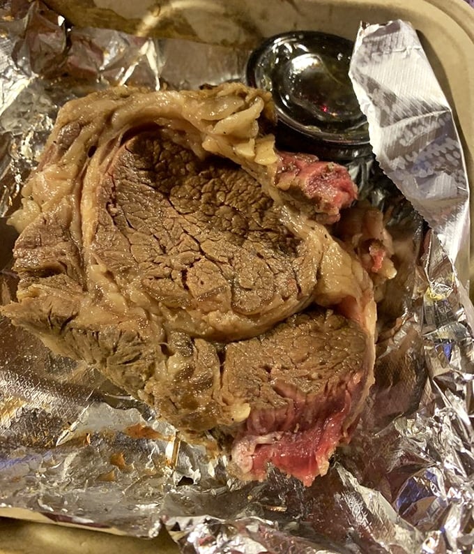 This prime rib isn't just cooked—it's been on a slow, patient journey to perfection. The foil-wrapped package reveals its beefy treasure like a carnivore's Christmas morning.