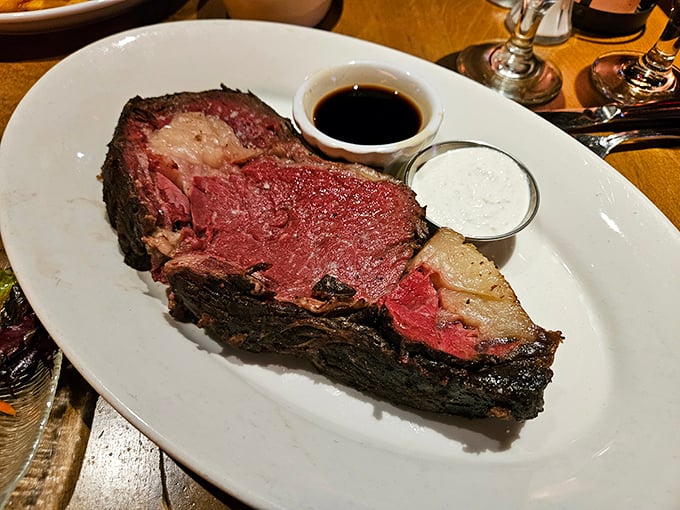 Behold the prime rib in its natural habitat: perfectly pink, accompanied by its faithful companions, au jus and horseradish cream. Poetry on a plate.