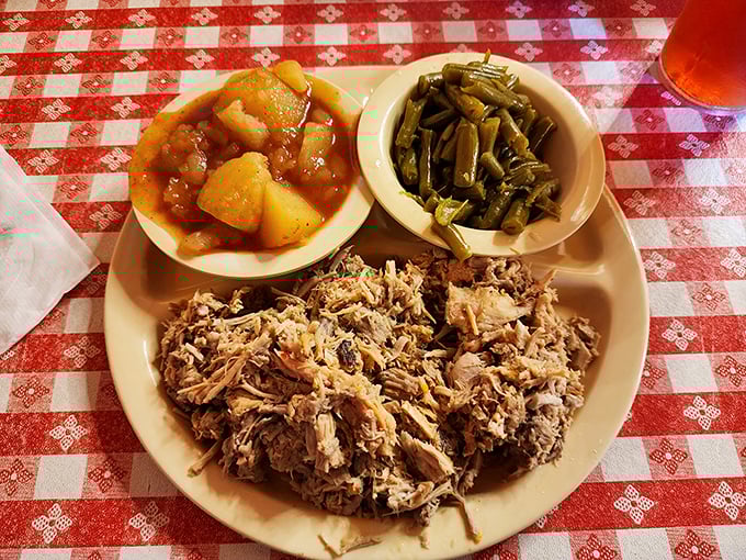 Behold the Eastern NC barbecue plate in all its glory—chopped pork with that vinegar tang, Brunswick stew, and collards. Heaven on a humble plate.