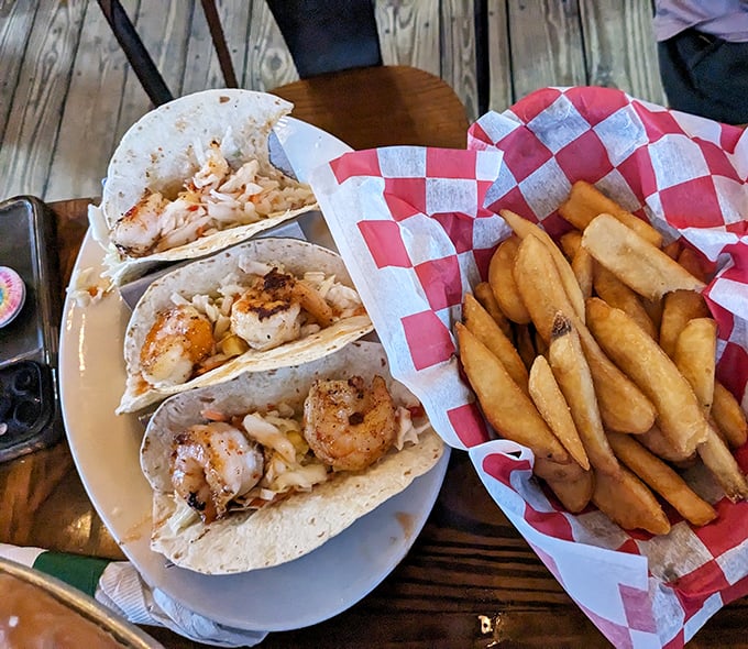 These shrimp tacos aren't just food; they're little fabric-wrapped packages of joy. The golden fries alongside are the beach vacation sidekick you didn't know you needed.