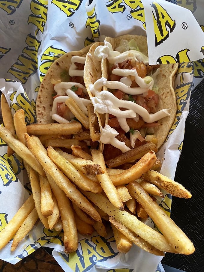 These aren't just tacos; they're edible postcards from paradise. Golden fries and seafood wrapped in tortillas – vacation on a plate.
