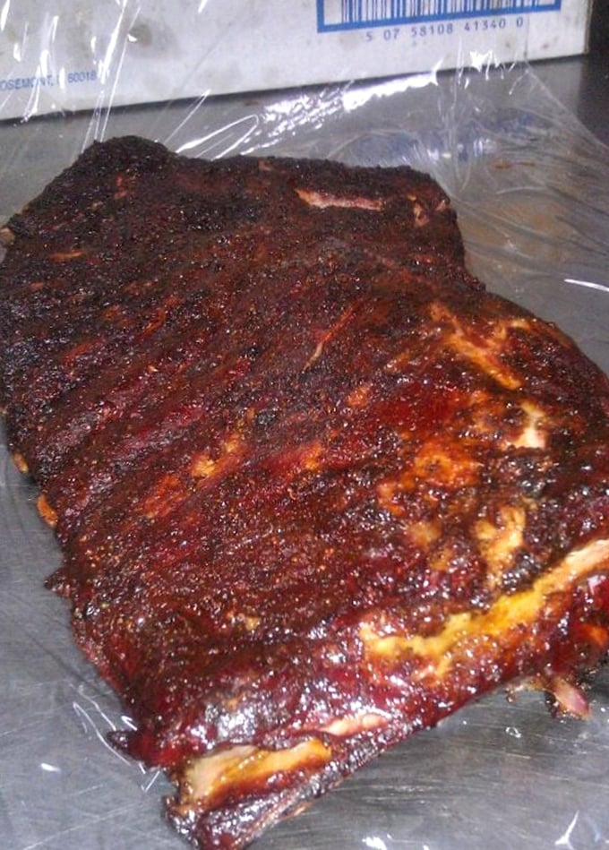 These spare ribs aren't just cooked—they're transformed into glistening, spice-crusted monuments to patience and fire.