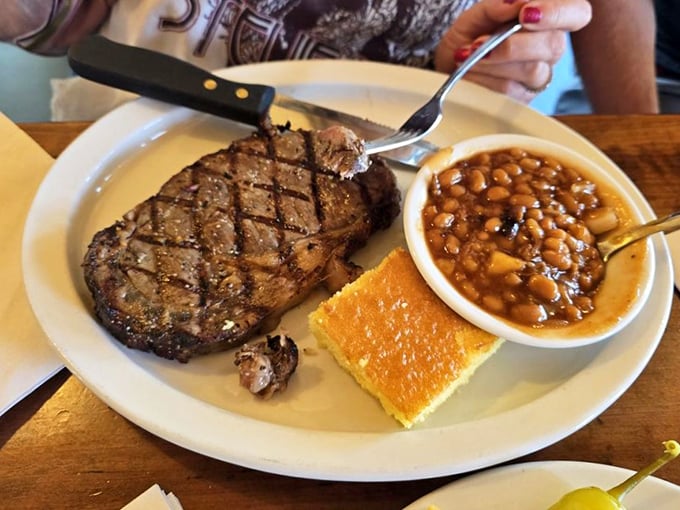 This isn't just a steak; it's a masterclass in simplicity – perfect grill marks, a side of beans, and cornbread that doesn't need to shout for attention.