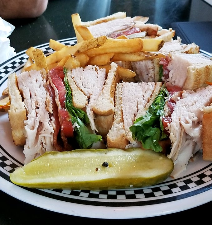 This club sandwich isn't just stacked – it's architected. With layers that would make Frank Lloyd Wright proud and a pickle that means business.