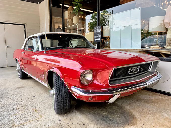 Classic American muscle meets antique shopping. This cherry-red vintage Mustang proves that sometimes the merchandise outside is just as impressive as what's inside.