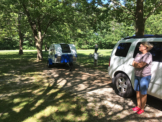 Camping done right – a teardrop trailer nestled among trees that have witnessed more family vacations than a station wagon.