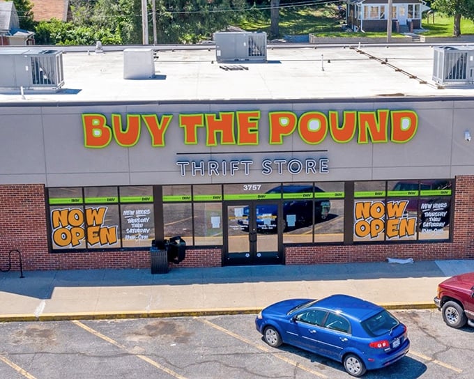 "BUY THE POUND" blazes in cheerful orange and green – a concept so brilliant you'll wonder why all thrift stores don't do this.
