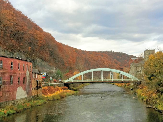 Oil City’s arched bridge spans the Allegheny River, framed by autumn hillsides and weathered brick reminders of the city’s industrial past.