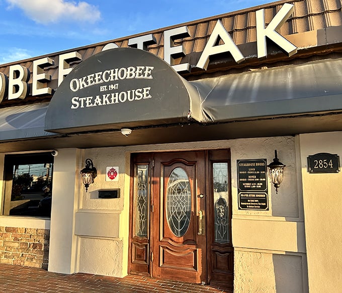That elegant doorway at Okeechobee Steakhouse isn't just an entrance—it's a time portal to when steaks were steaks and vegetables knew their place.