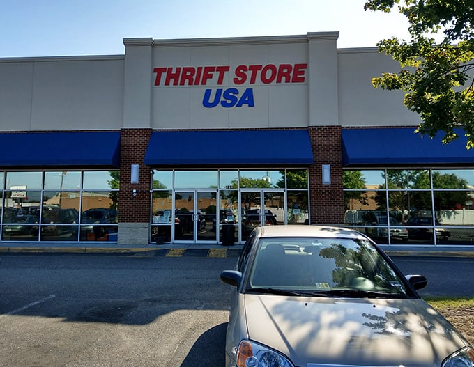 The thrift store parking lot—where hopeful shoppers arrive with empty trunks and leave with cars riding suspiciously low to the ground.