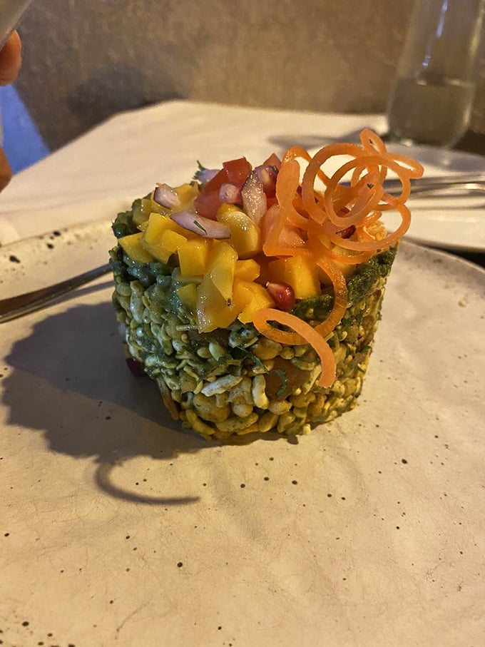 The Avocado Mango Bhel is architectural genius on a plate—crispy puffed rice supporting sweet mango and creamy avocado, crowned with spirals of carrot that add both color and crunch.