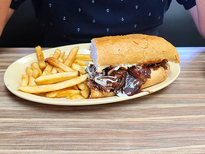 This isn't just a sandwich; it's a masterclass in comfort—tender BBQ beef nestled in French bread with crispy fries standing at attention.